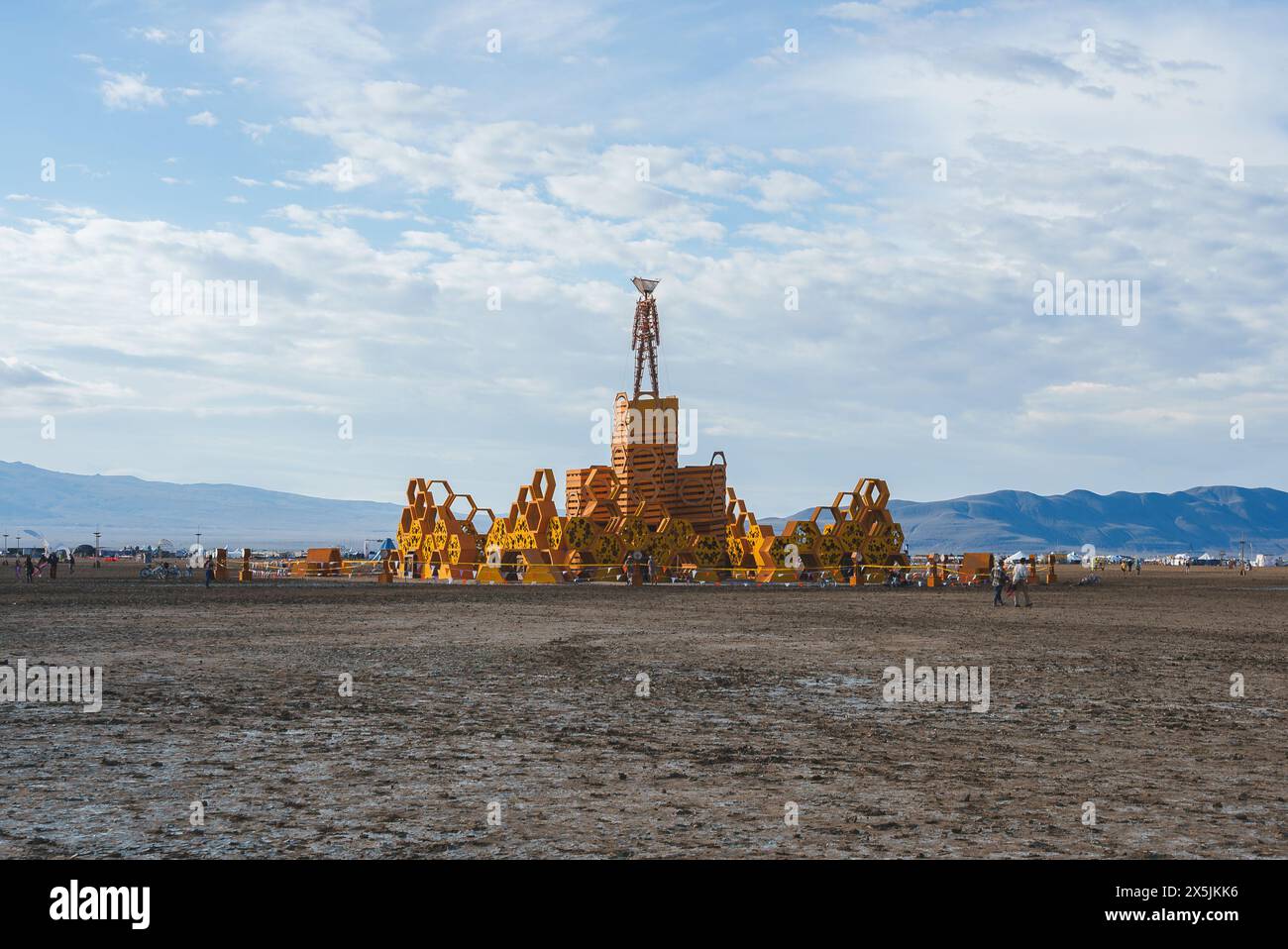 Intricate wooden structure in vast desert landscape with crowd ...