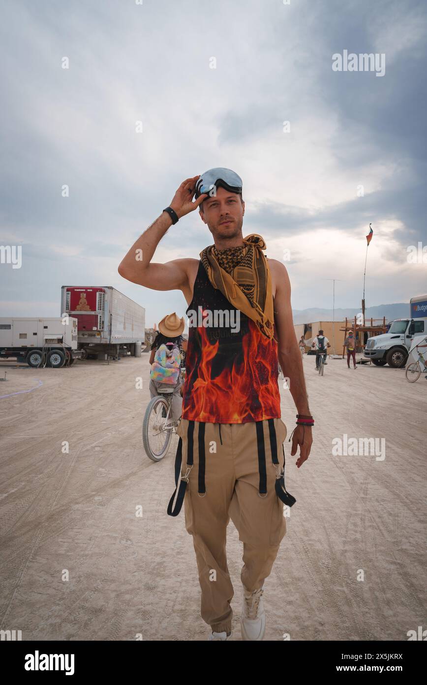 Festival goer in desert landscape with vehicles and flag Stock Photo ...