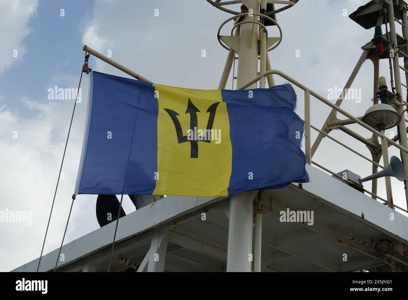 Flying Barbados flag, vertical triband of ultramarine and gold with the ...