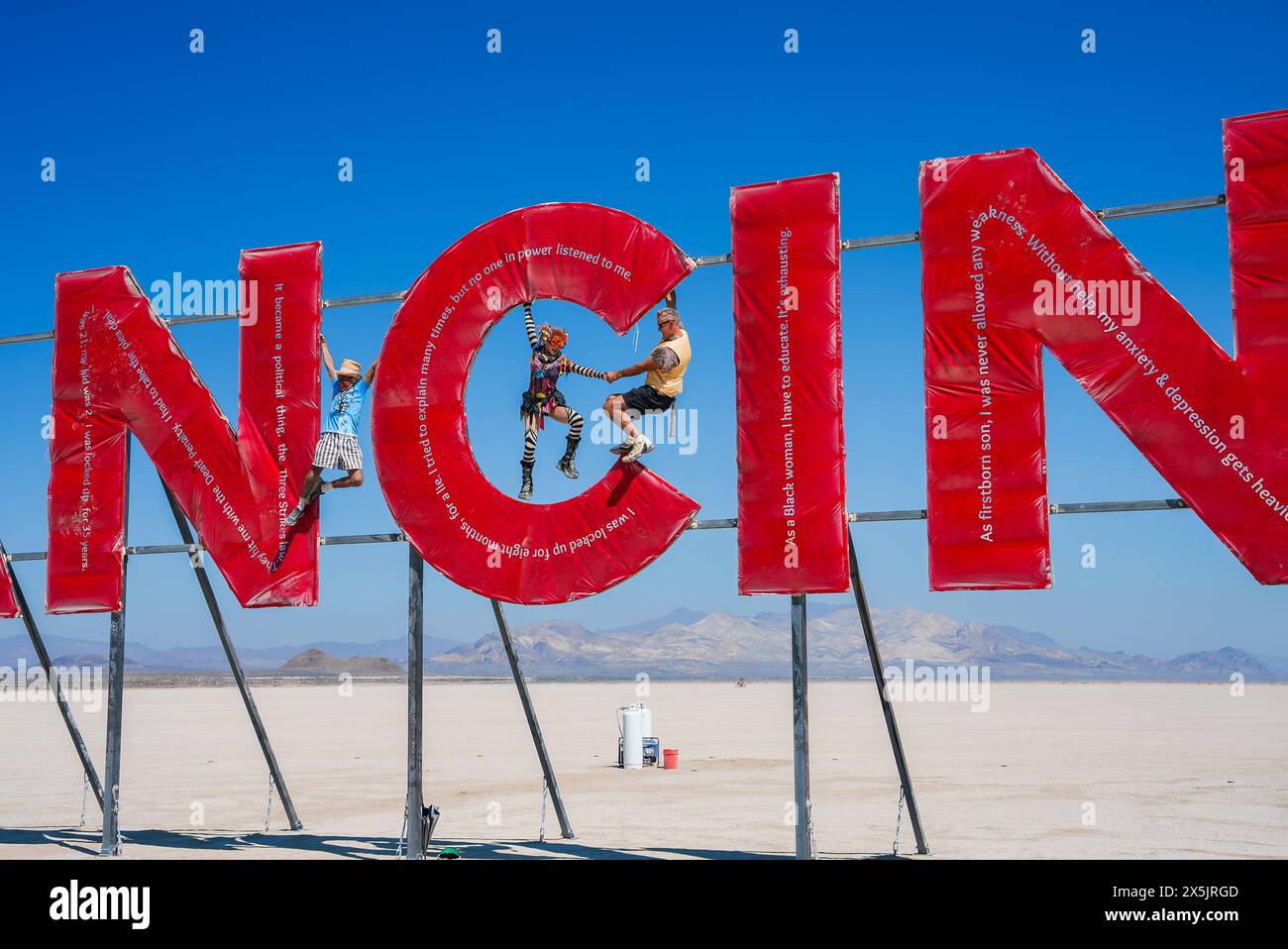 Bold Red Sign in Desert Setting, Person Climbing Letter C Stock Photo ...
