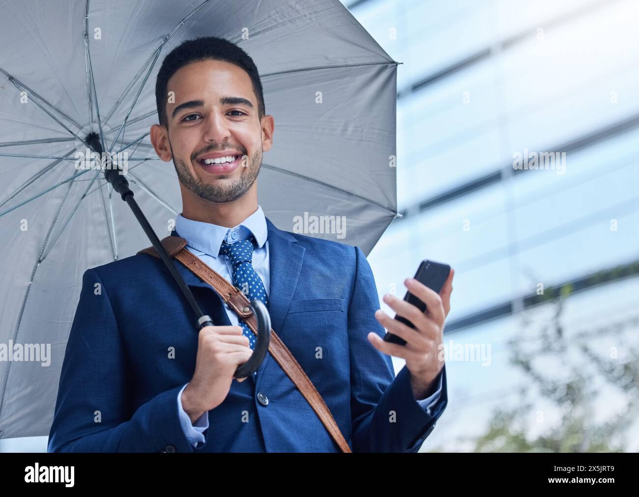 Businessman, mobile and umbrella with communication in city for justice, advocate for legal with ...