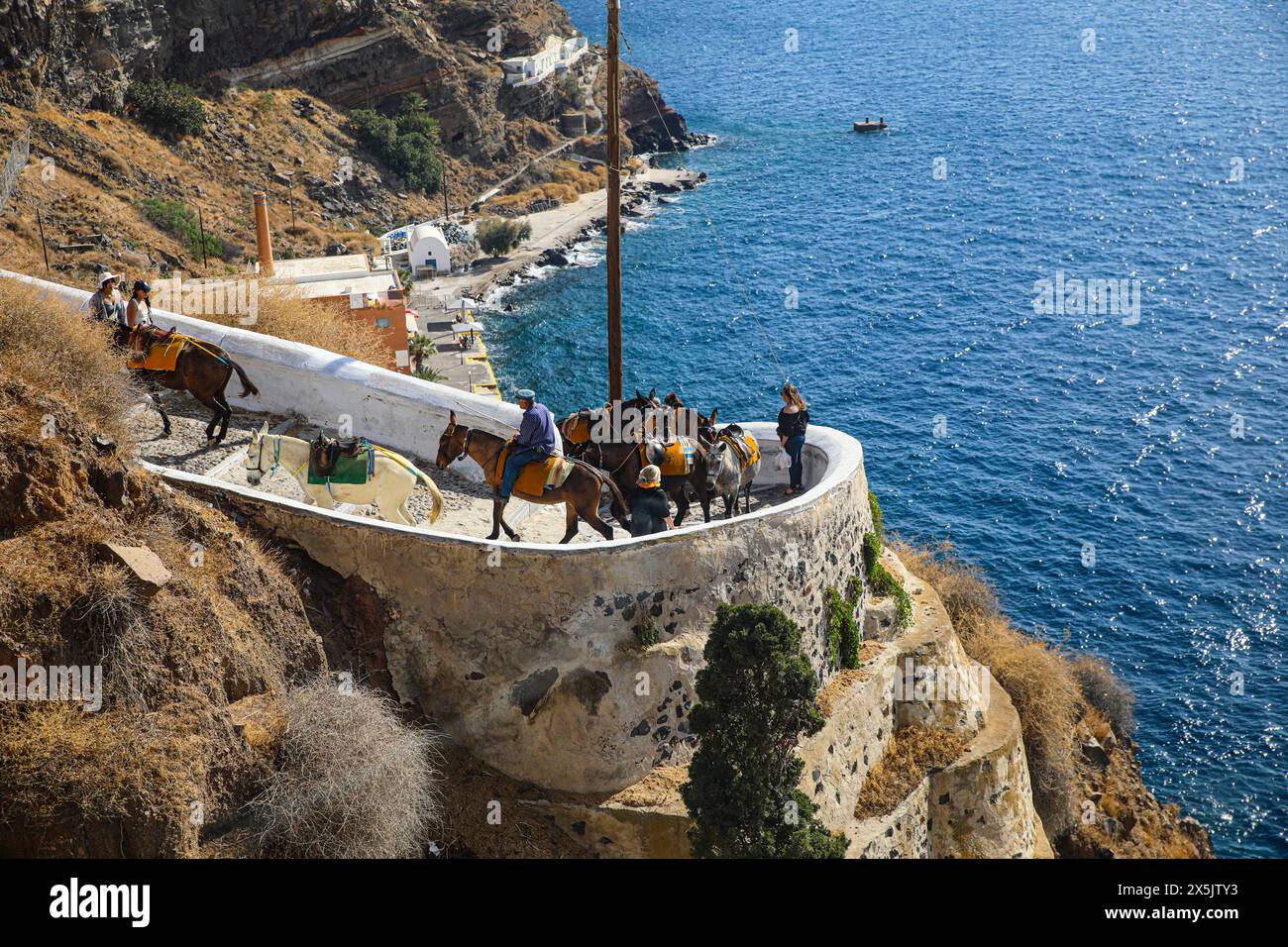 Thira, Santorini, Greece. Tourists riding donkeys on the Santorini ...