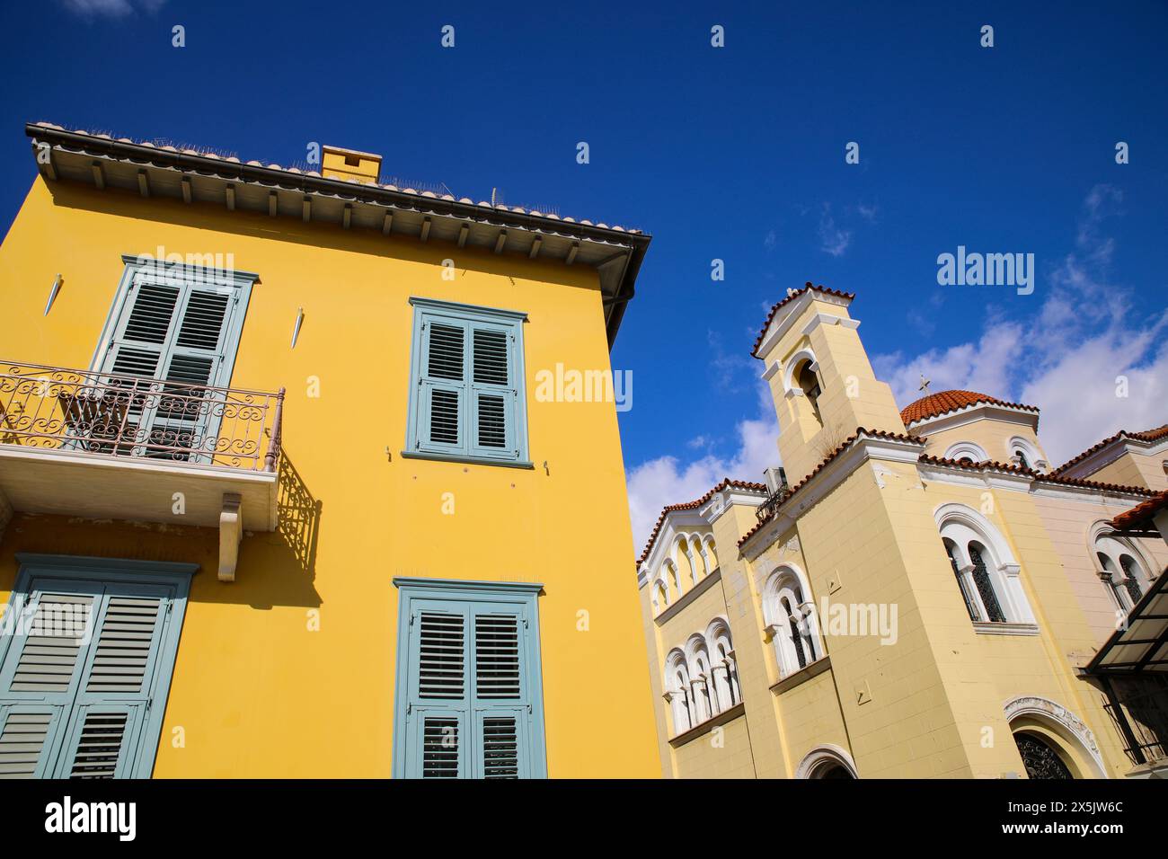 Athens, Greece. Yellow Mediterranean building with balconies and blue ...