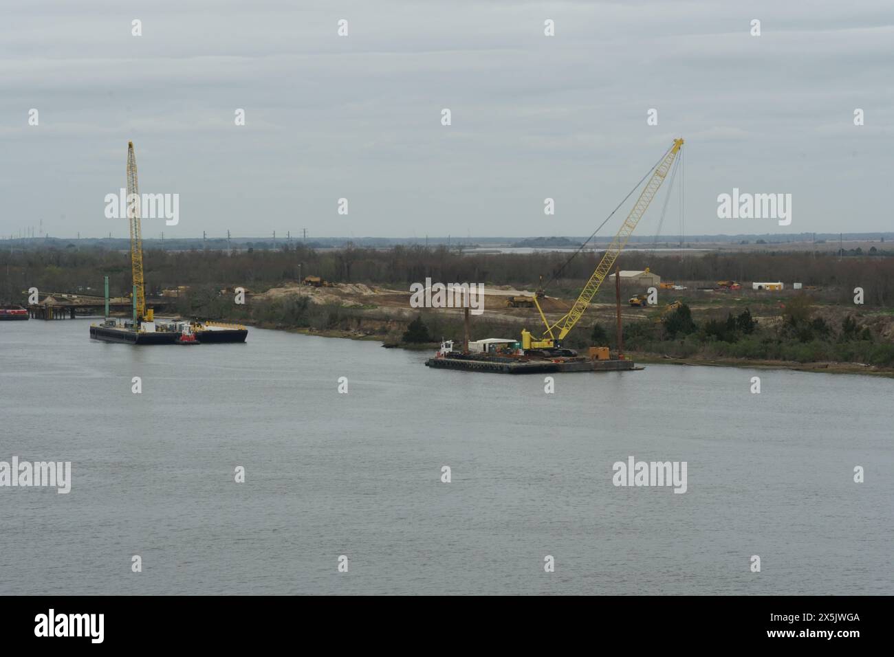Heavy machinery crane on floating barge near the left bank of the ...