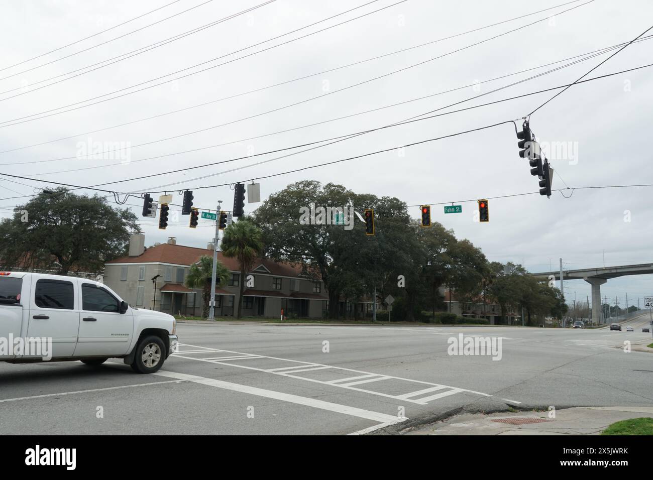 A white car at an intersection stopping at a red light shown by the ...