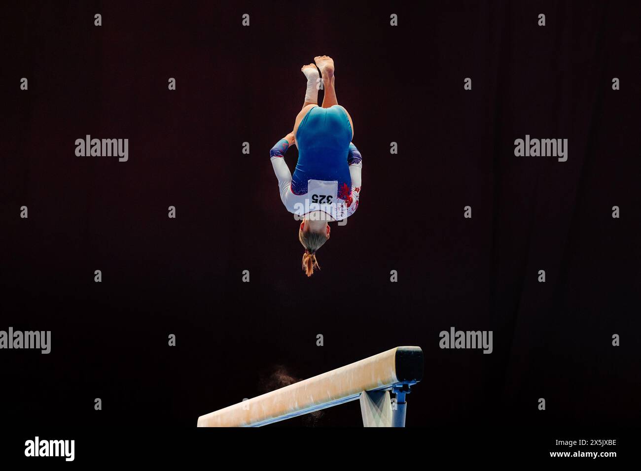 woman exercise on balance beam gymnastics, perform backward somersault ...