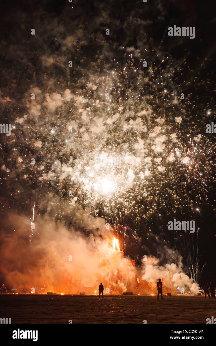 Vibrant fireworks display at music and art festival in desert at night ...
