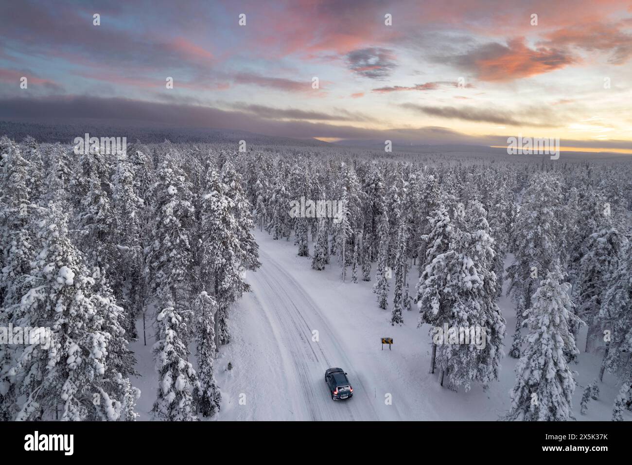 Car driving through the snowy wood in the dramatic winter landscape of ...