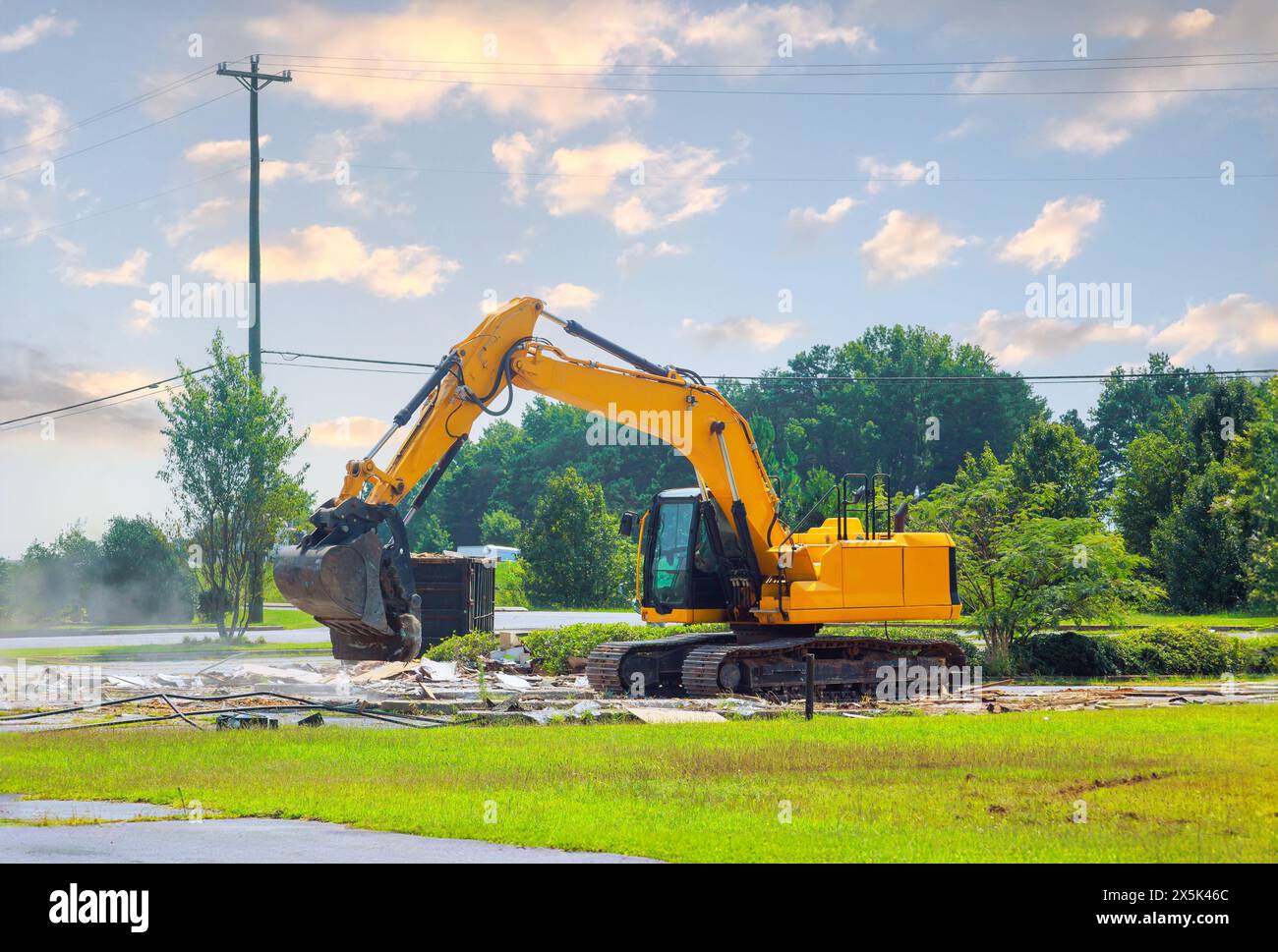 An excavator loads construction concrete waste into dump container ...