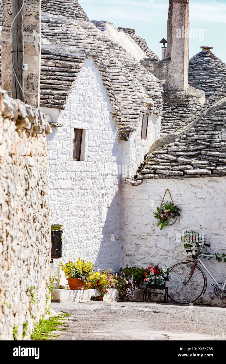Alberobello, Italy, Bari. White washed Trulli houses, a bicycle, wicker ...