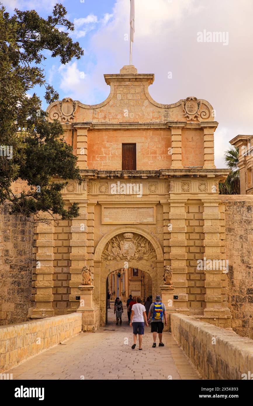 Rabat, Mdina, Malta. People on bridge walk into the old town of Mdina ...