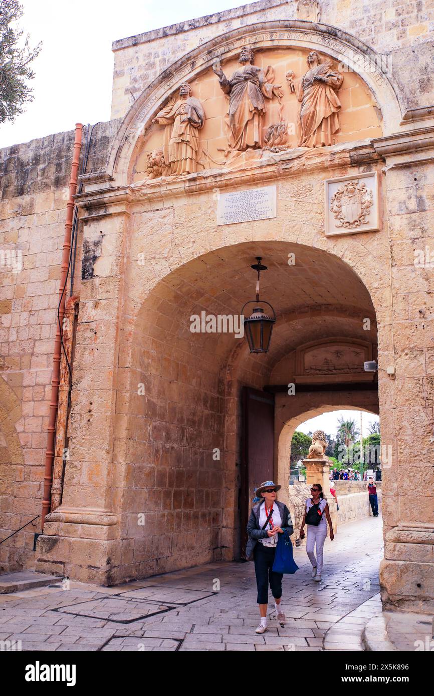 Rabat, Mdina, Malta. Tourists enter old town Mdina through walled city ...