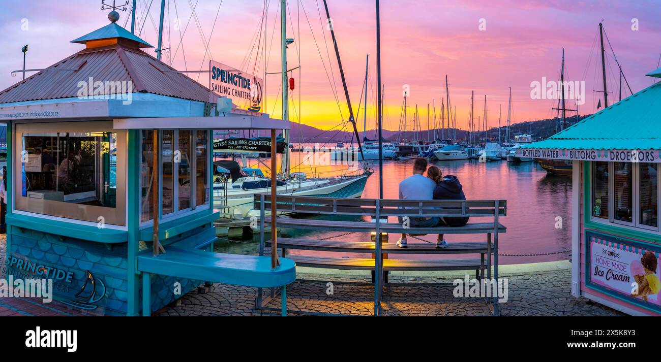 View of couple watching golden sunset at Knysna Waterfront, Knysna ...