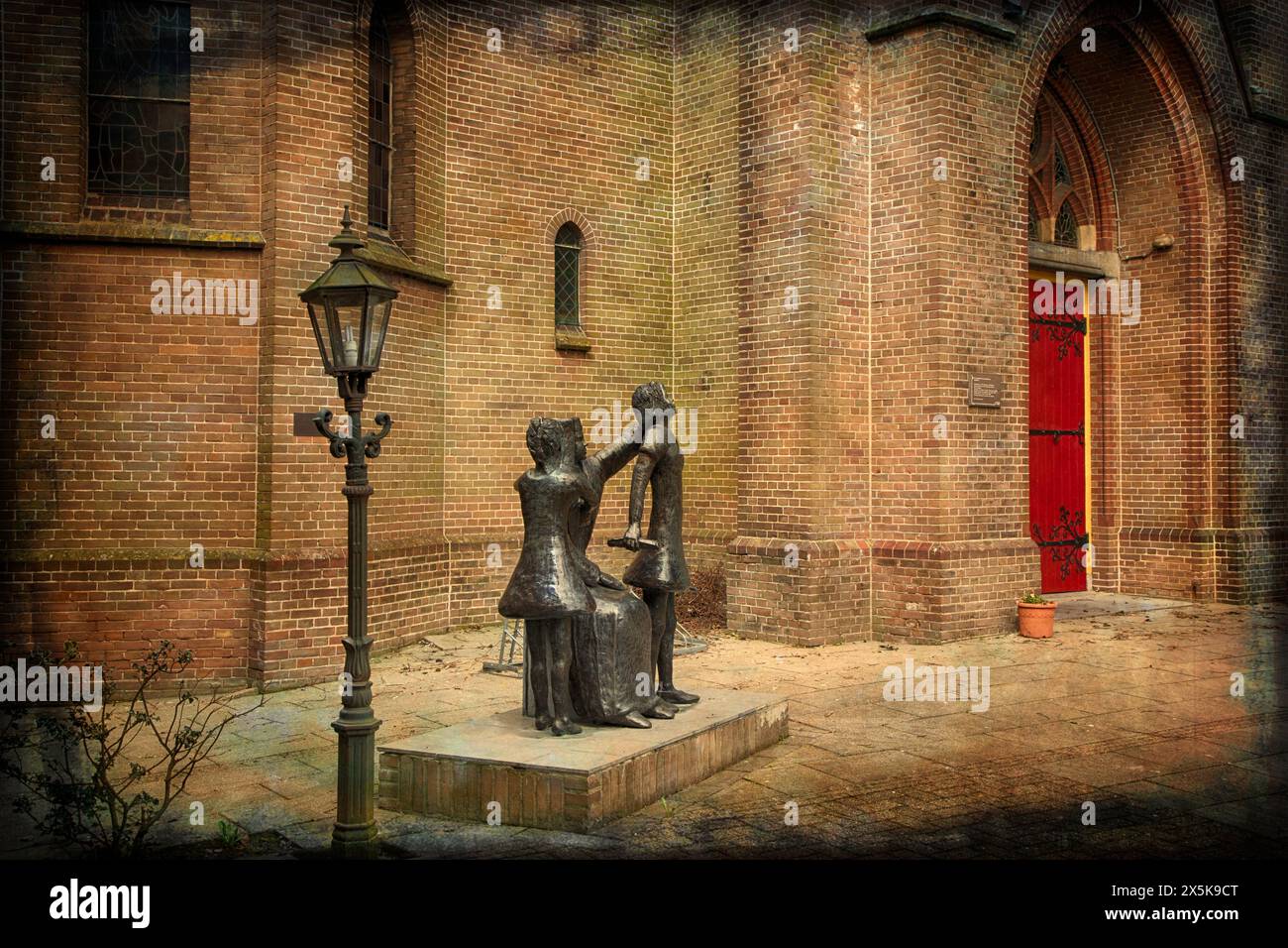 Bronze statue of a seated sister with two students. The statue stands ...
