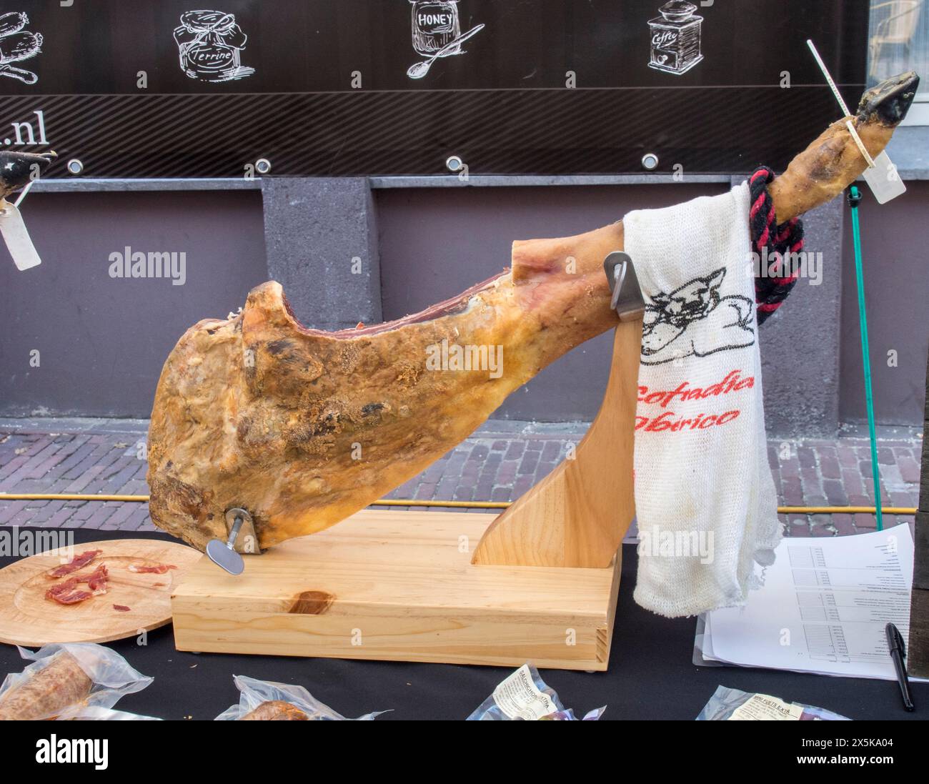 A prosciutto ham being sliced and on display at a shop in the town of ...
