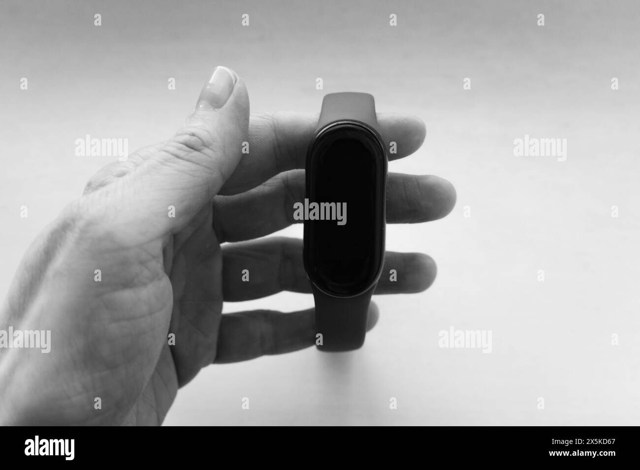 Hand holding fitness tracker with mockup screen, black and white. Sport ...