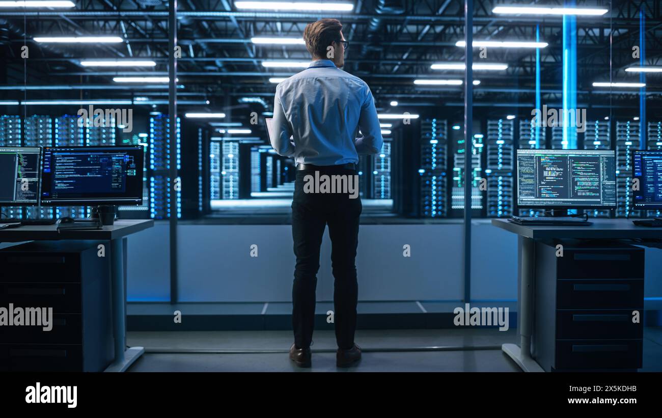 High-Tech Startup Concept: Innovative Male Software Engineer Standing, Doing Big Data Analysis ...