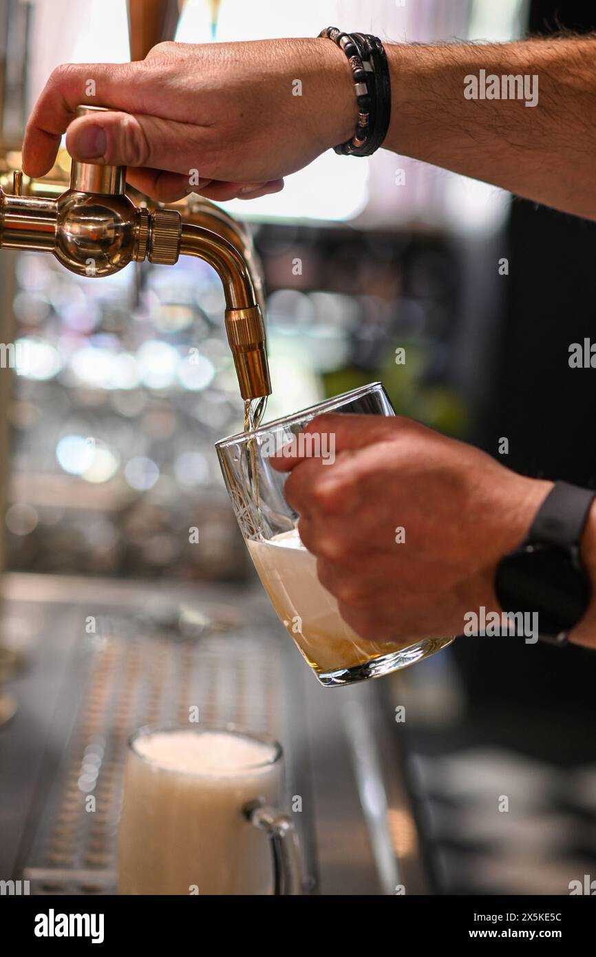 the waiter is capping a beer at the bar Stock Photo - Alamy