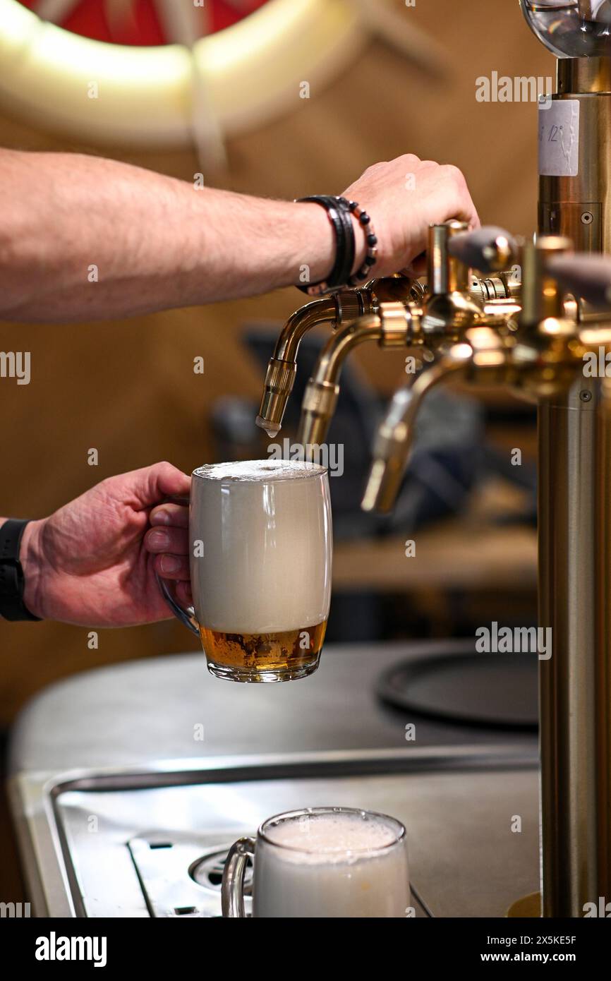 the waiter is capping a beer at the bar Stock Photo - Alamy