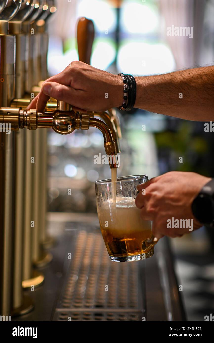 the waiter is capping a beer at the bar Stock Photo - Alamy