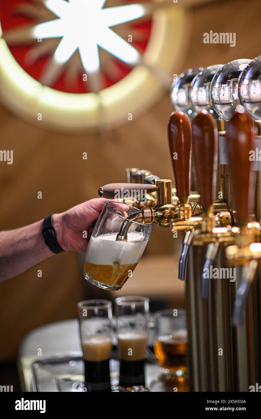 the waiter is capping a beer at the bar Stock Photo - Alamy
