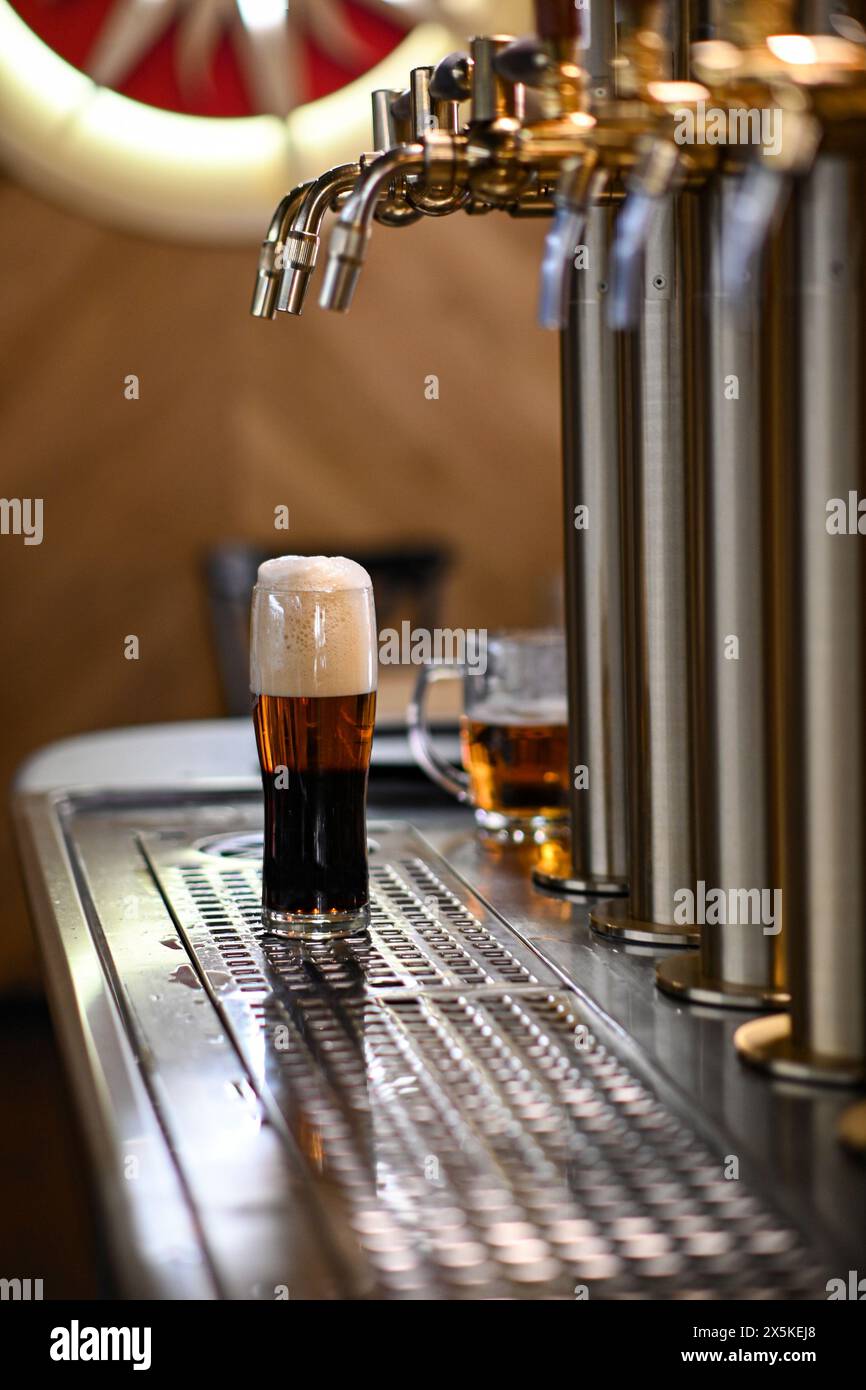 the waiter is capping a beer at the bar Stock Photo - Alamy