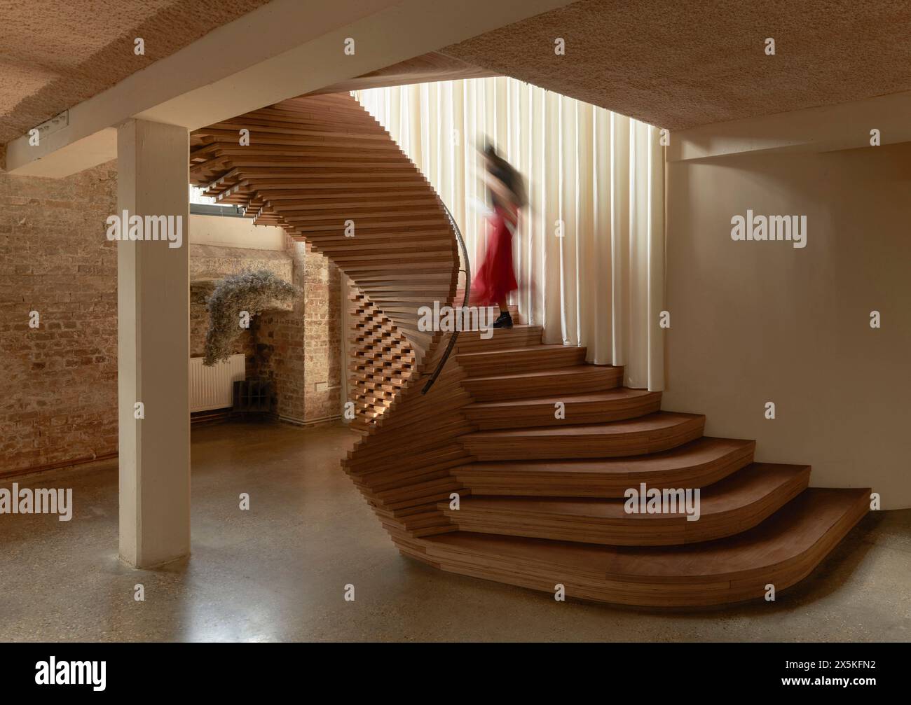 Sculptural curvaceous timber staircase with figure ascending. ACME ...