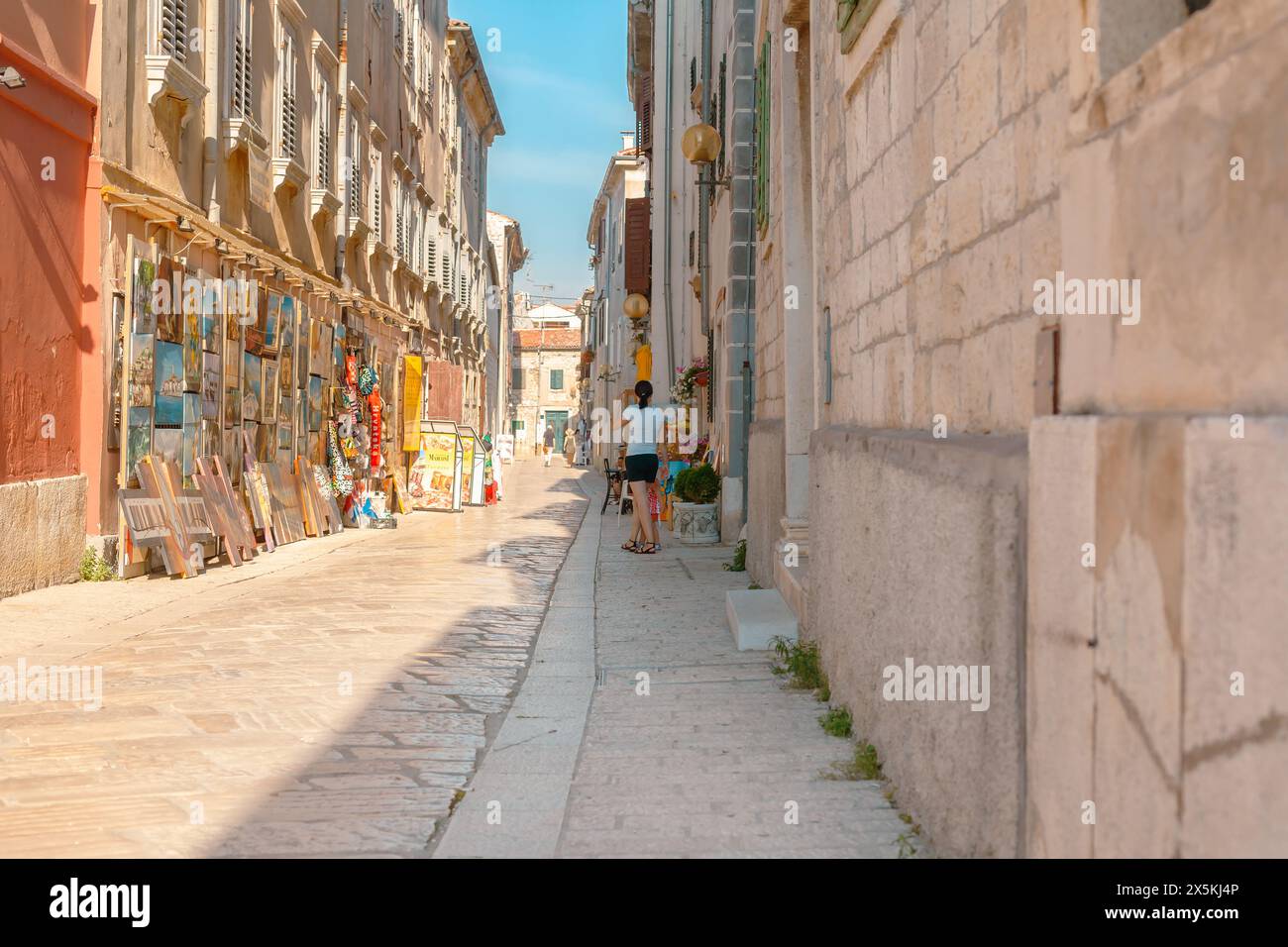 Picturesque Mediterranean street with outdoor cafes and people walking ...