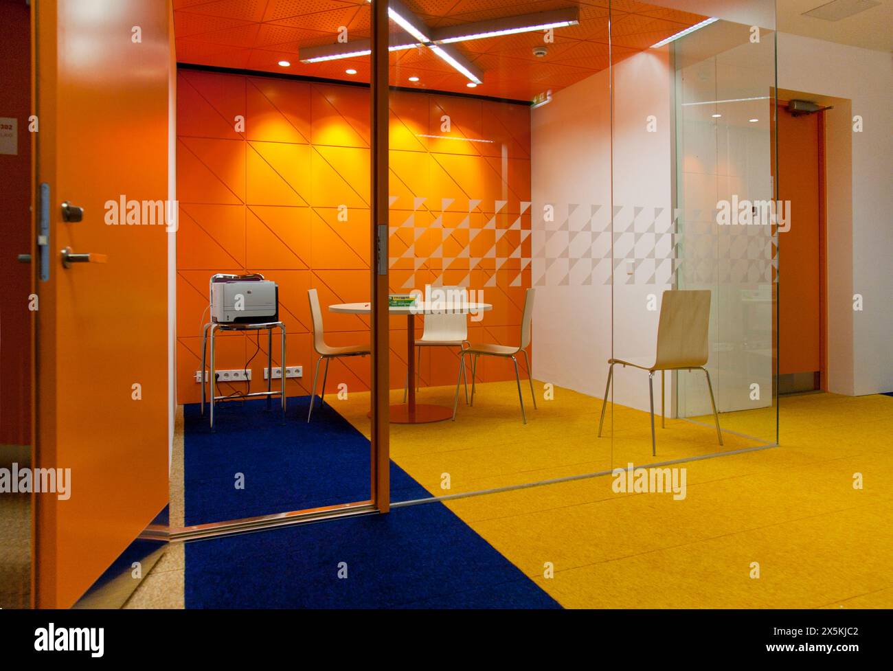 Modern meeting area in an office, a clear glass wall and chairs and ...