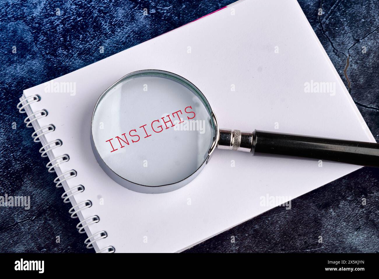 Insight concept. INSIGHTS word through a magnifying glass in a notebook ...