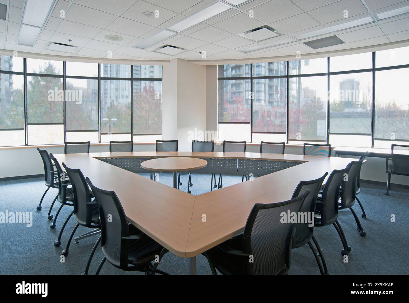 Large empty boardroom. A long narrow table in a triangle formation with ...