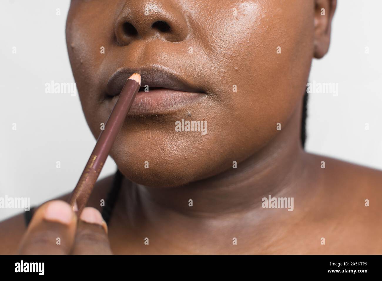 Brown skin woman applying a brown lip liner, dark skinned woman using ...