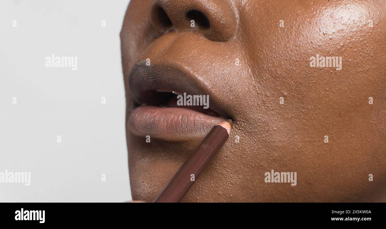 Brown skin woman applying a brown lip liner, dark skinned woman using ...