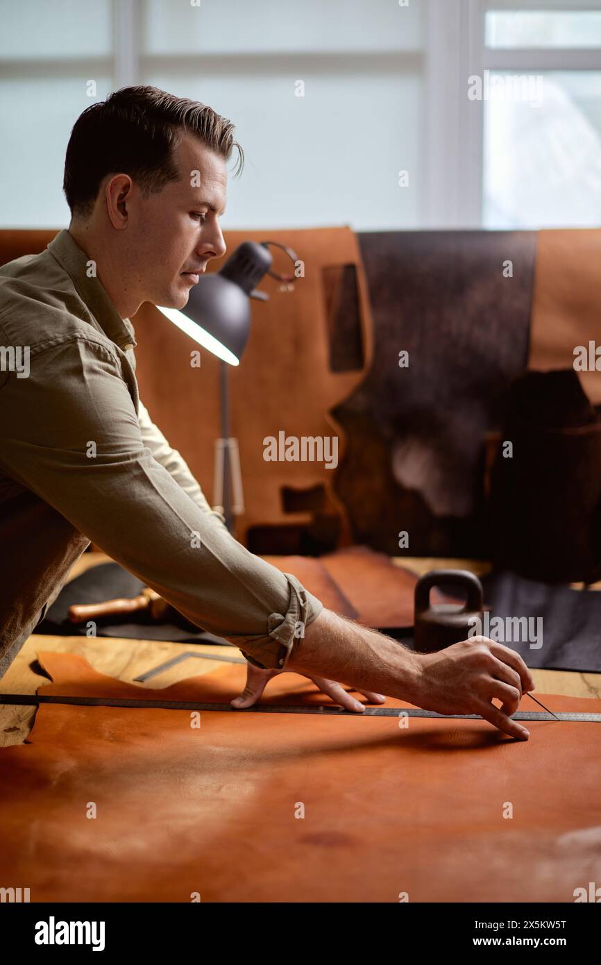 skilled tailor cuts and measures fabric according to a pattern or ...