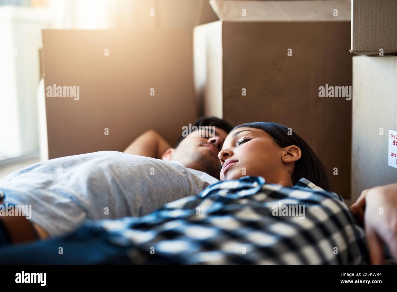 Couple, rest and sleeping by boxes in new home with relax for property ...