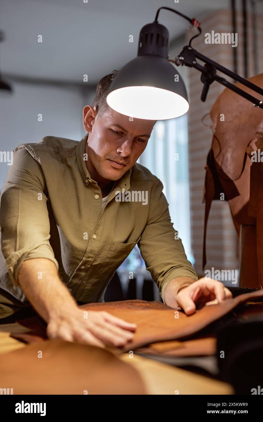 Working process of the leather bag, shoes in the leather workshop. handsoem serious man holding ...