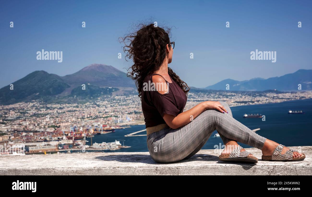 beautiful Mediterranean woman with curly hair enjoying the panorama of ...