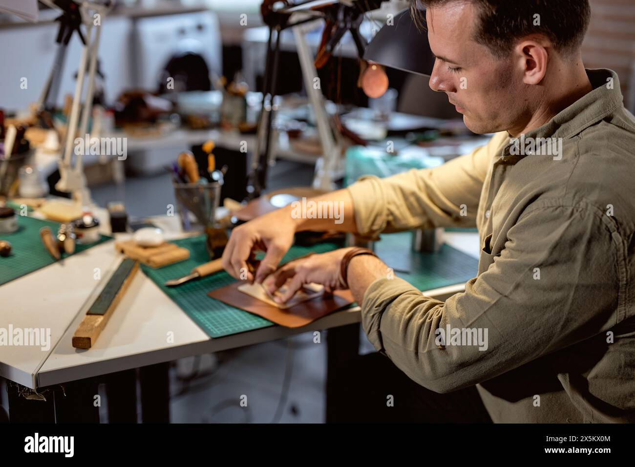 young man uses awl for measuring. close up side view shot.Detail work ...