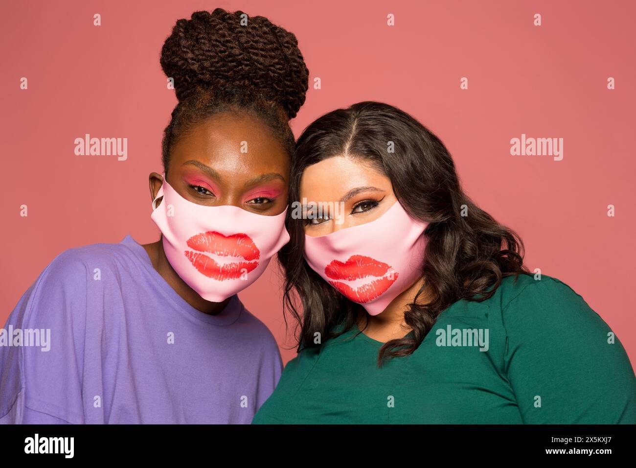 Studio portrait of two young women wearing face masks with lipstick ...