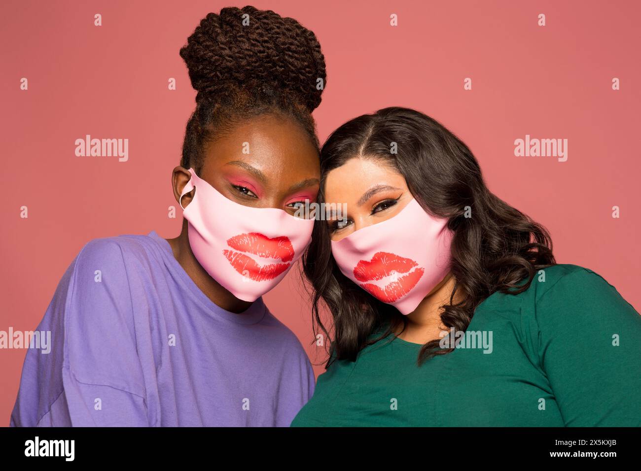 Studio portrait of two young women wearing face masks with lipstick ...