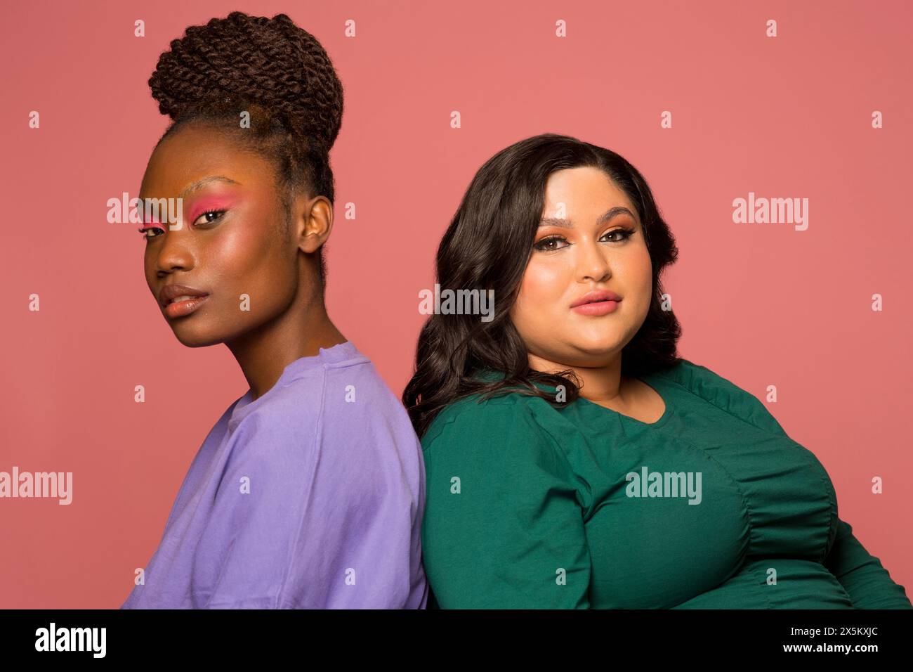 Studio portrait of two women back to back Stock Photo - Alamy