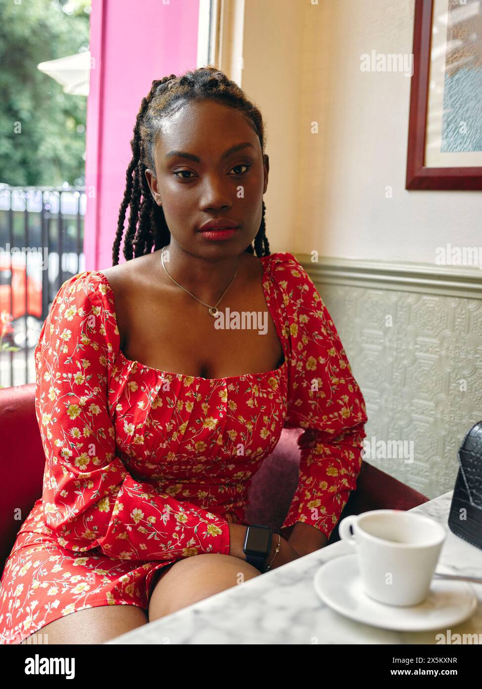 Portrait of woman in red dress sitting at cafe table Stock Photo - Alamy