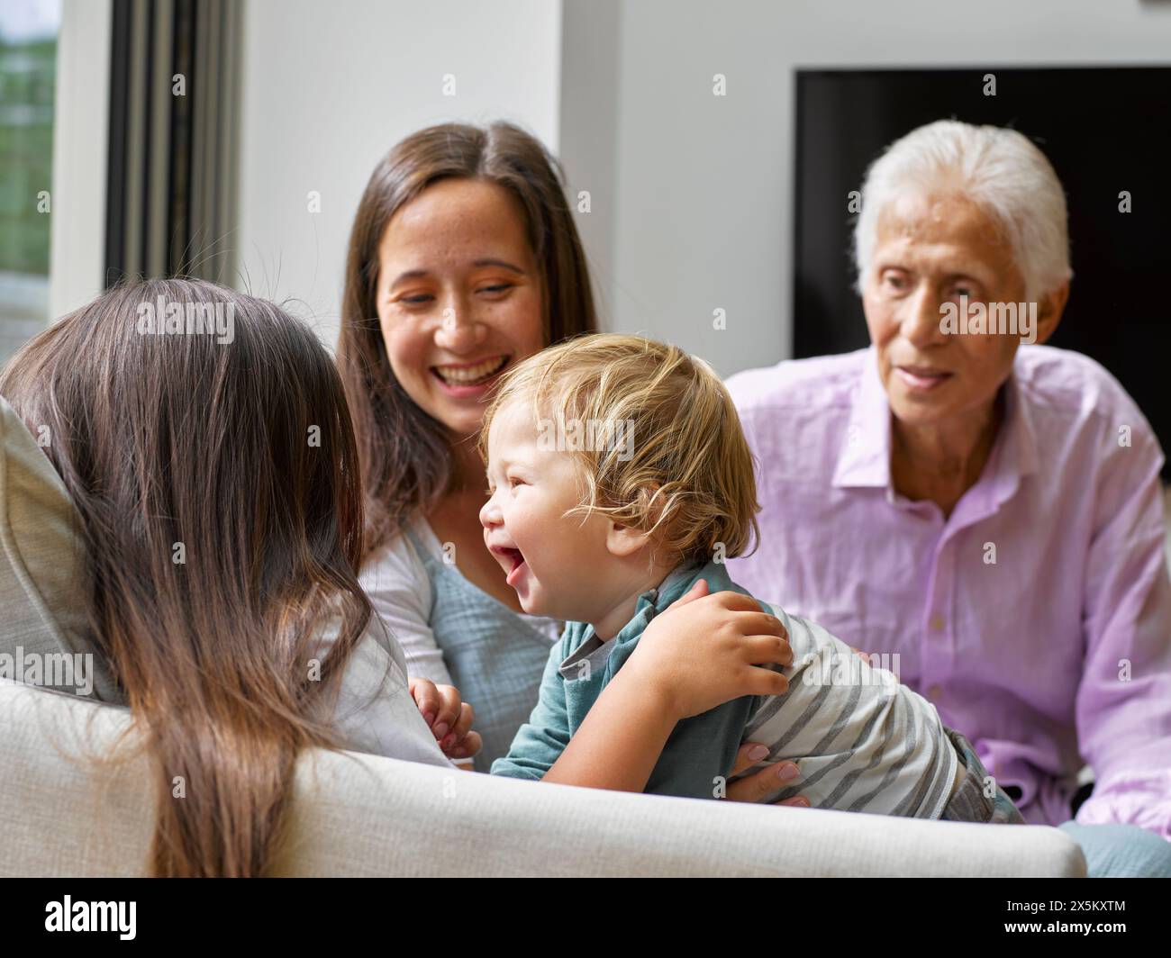 Multi generational family on sofa Stock Photo - Alamy