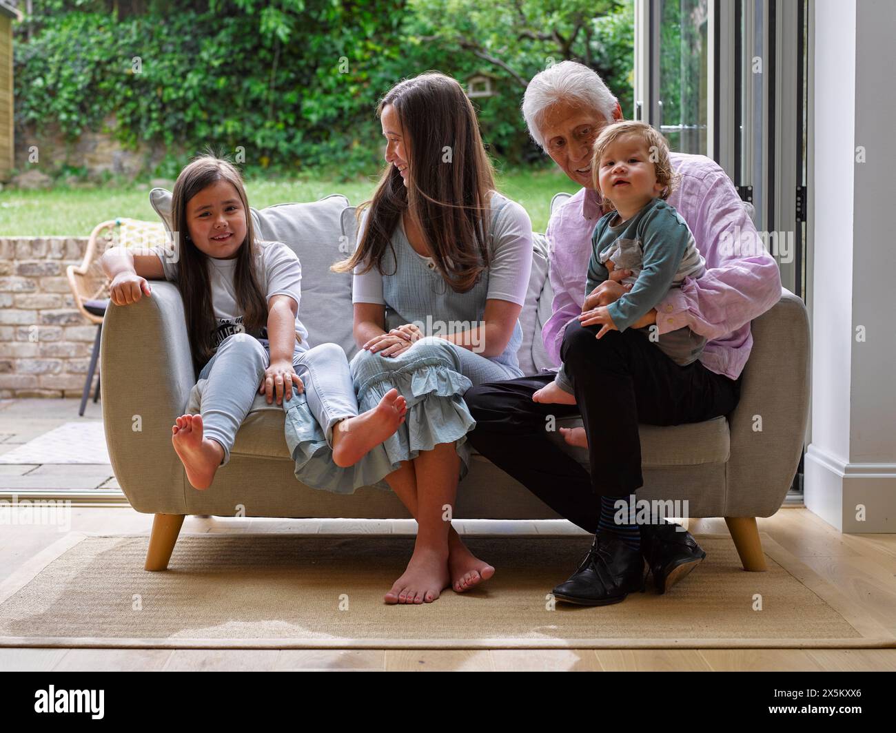 Family sitting smiling hi-res stock photography and images - Alamy