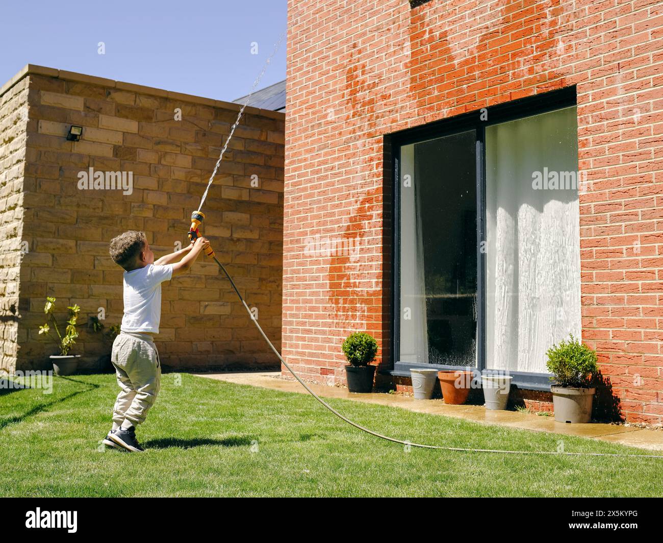 Water spraying boy hi-res stock photography and images - Alamy