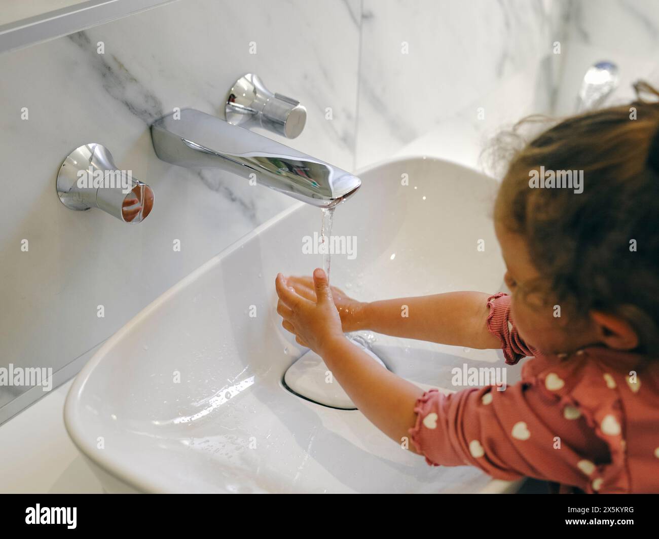 Baby girl washing hands Stock Photo - Alamy