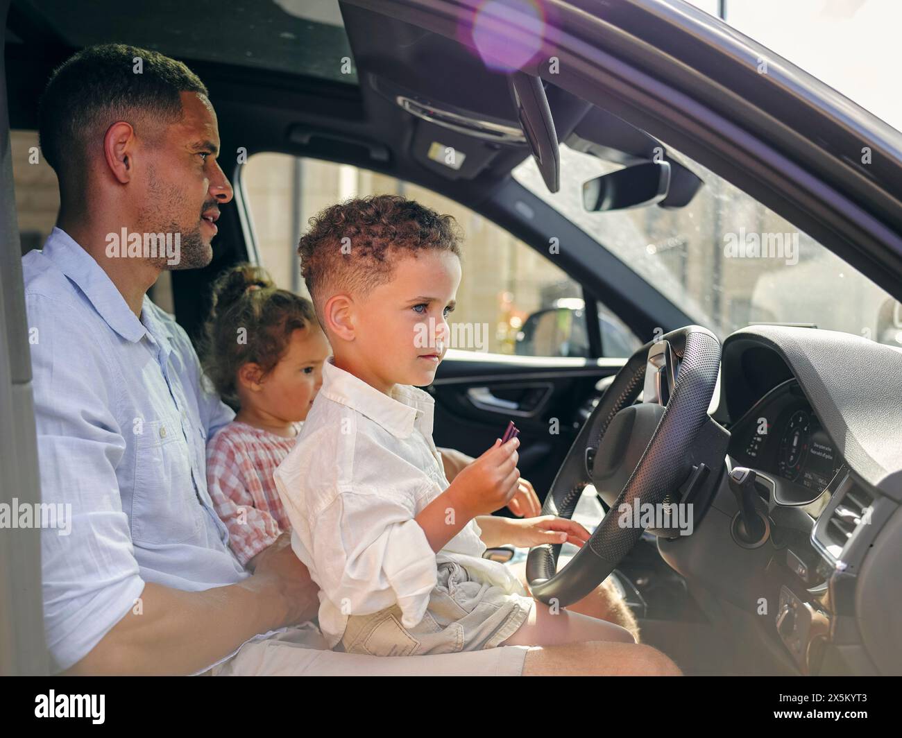 Father with two children sitting in car Stock Photo - Alamy
