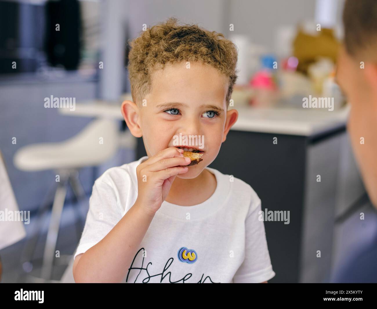 Boy eating snack at home Stock Photo - Alamy