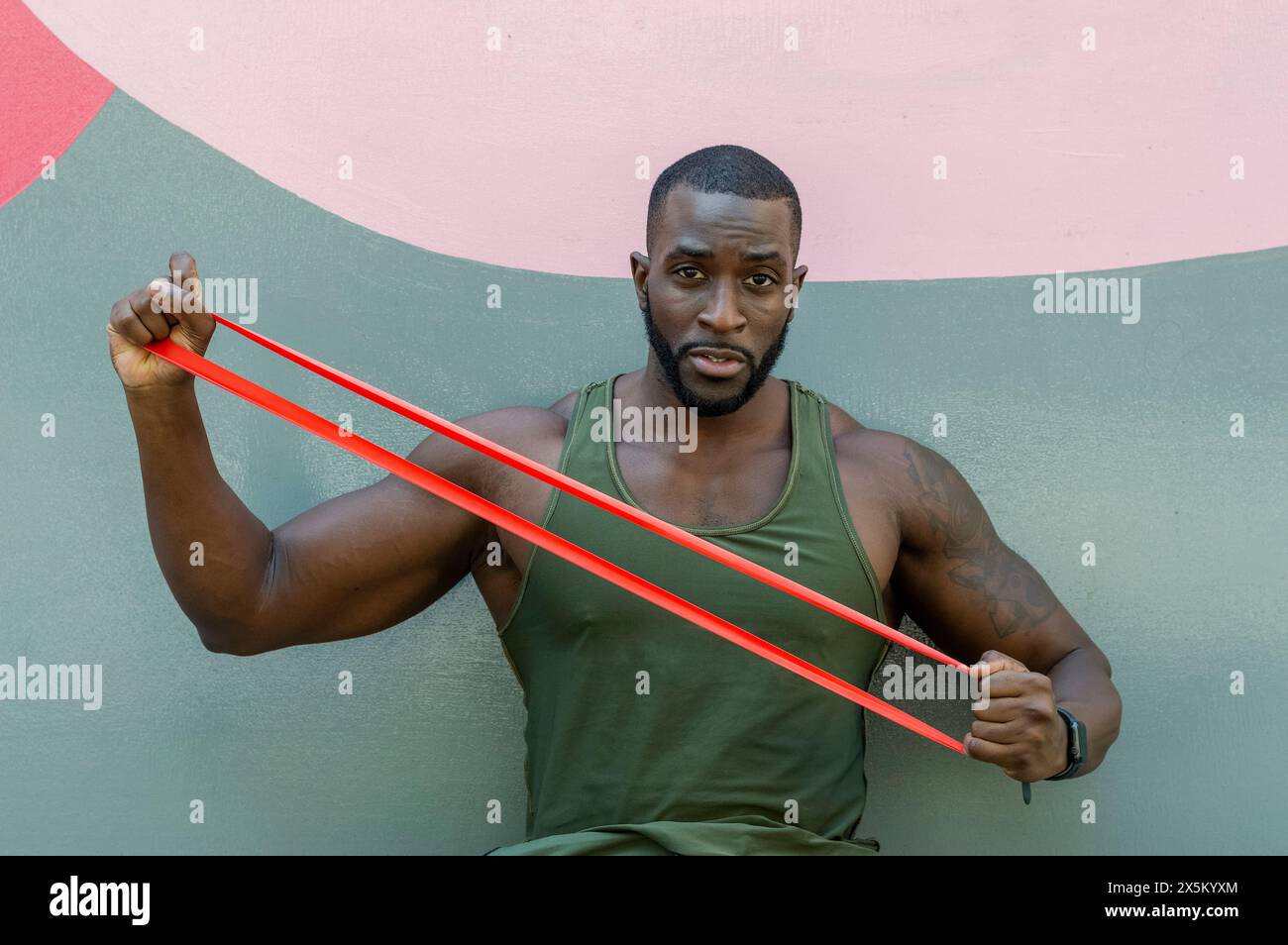 Portrait of mid adult man holding resistance band Stock Photo - Alamy