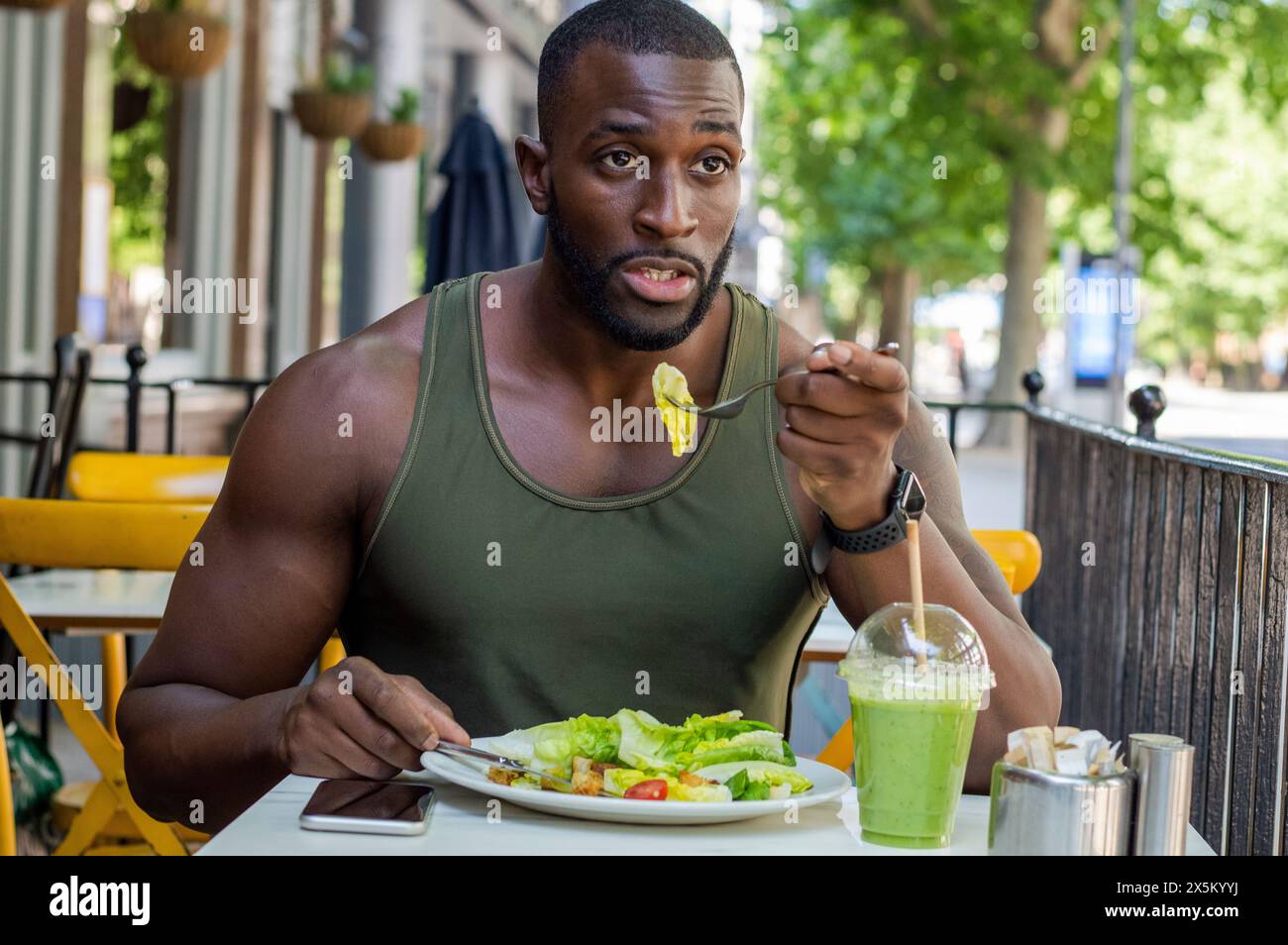 Mid adult man eating salad in cafe Stock Photo - Alamy